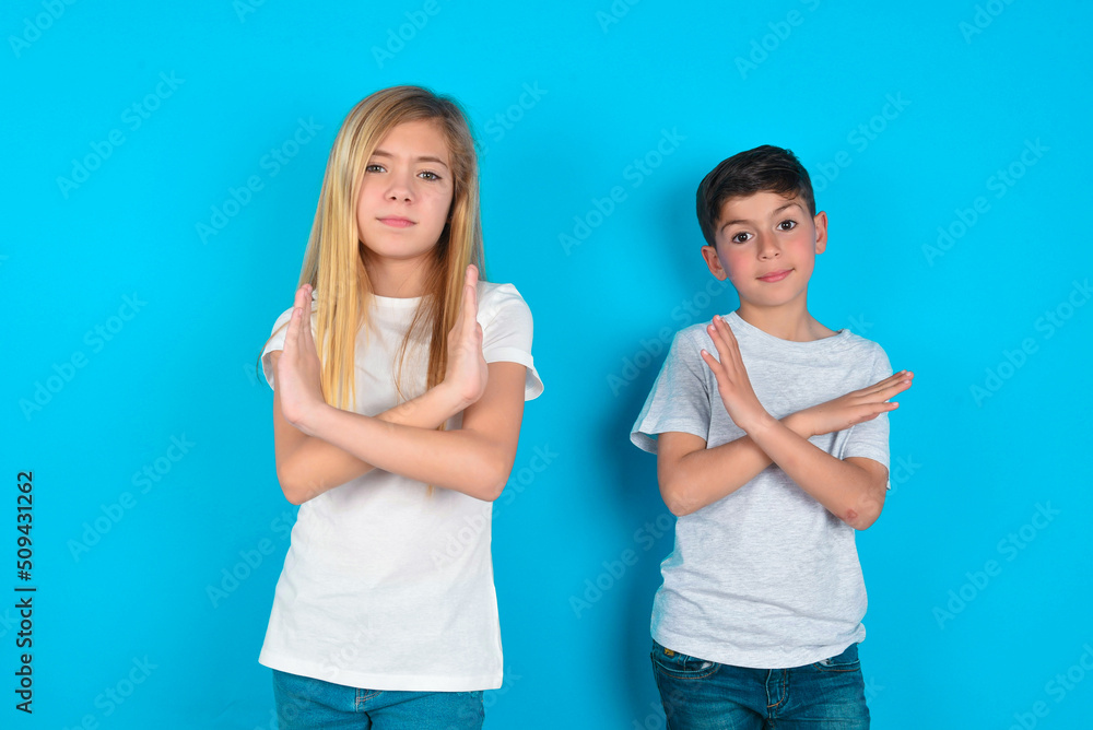 two kids boy and girl standing over blue studio background Has ...