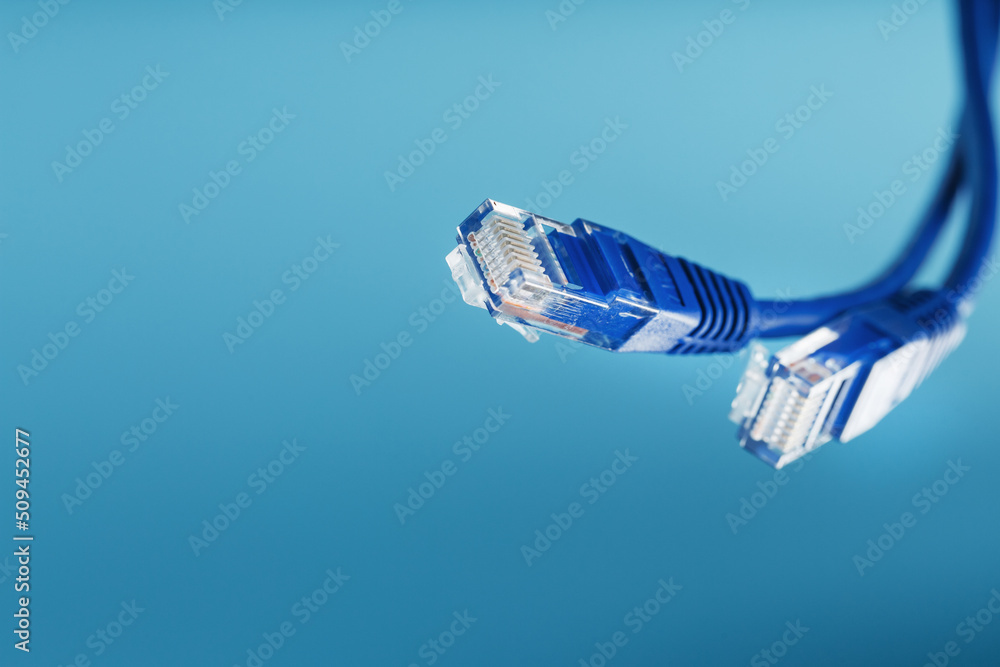 Two Ethernet Cable Connectors Patch cord cord close-up isolated on a blue background with free ...