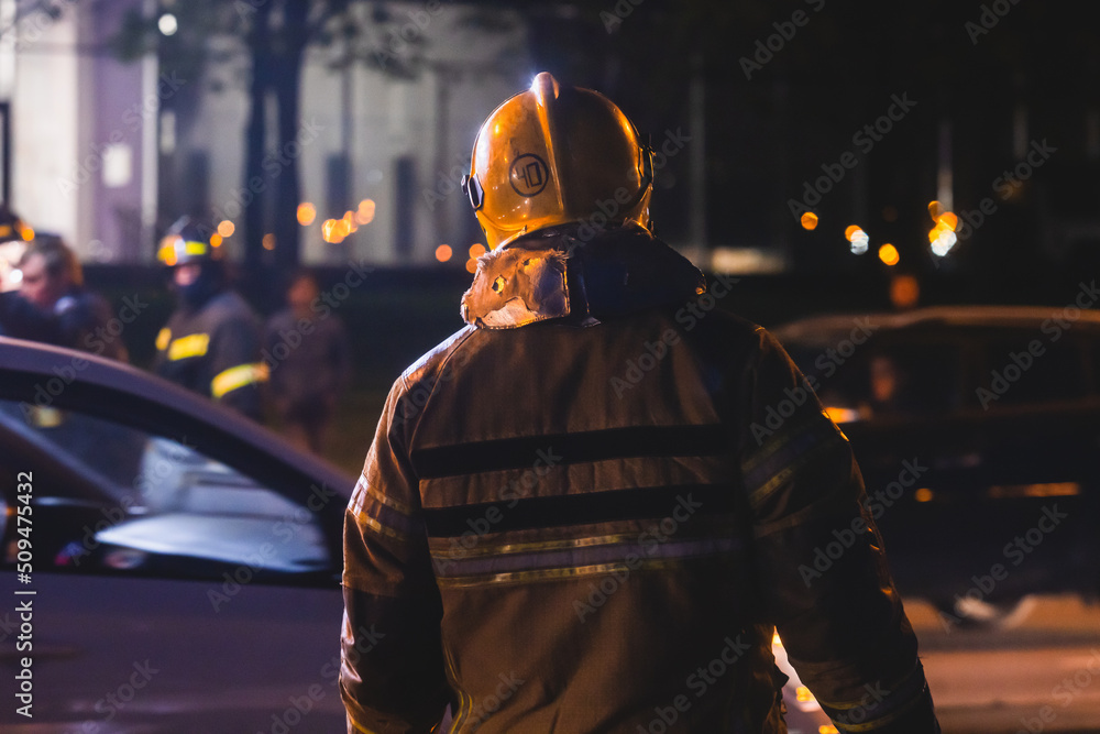 Group of fire men in uniform during fire fighting operation in the ...