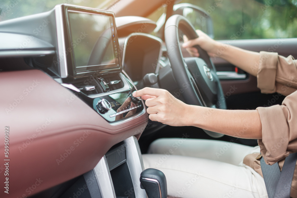 Woman hand adjusting temperature the air flowing during driving car on ...