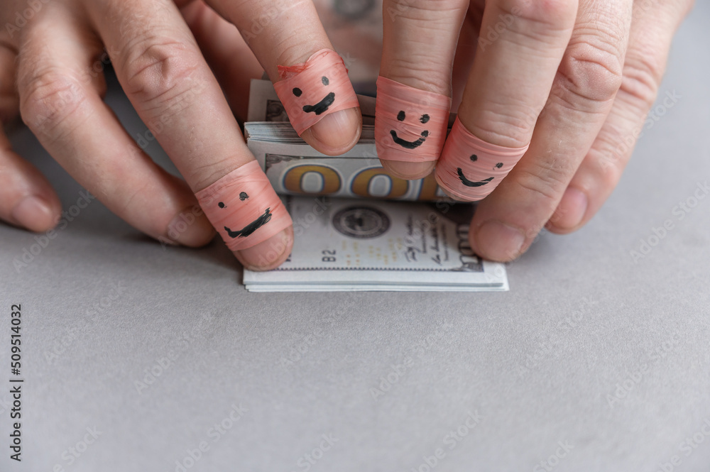 Man's fingers are counting money. Wad of American hundred-dollar bills ...