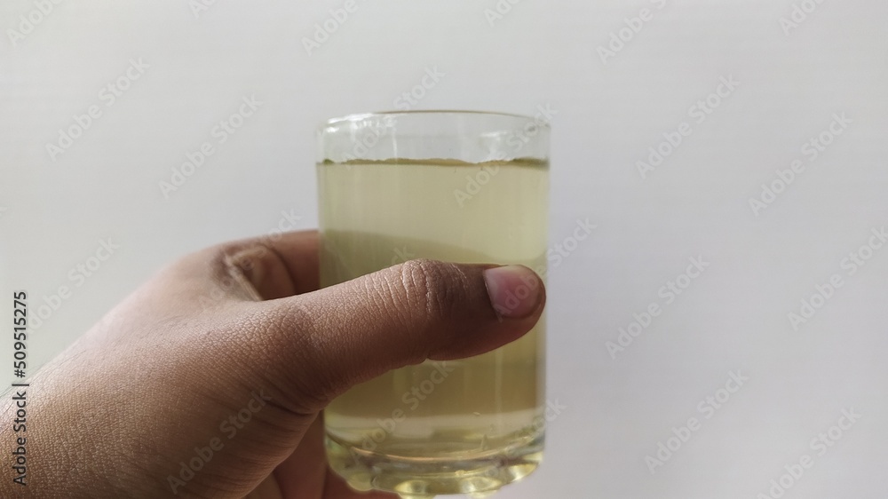Hand holding glass with brown contaminated undrinkable dirty drinking ...