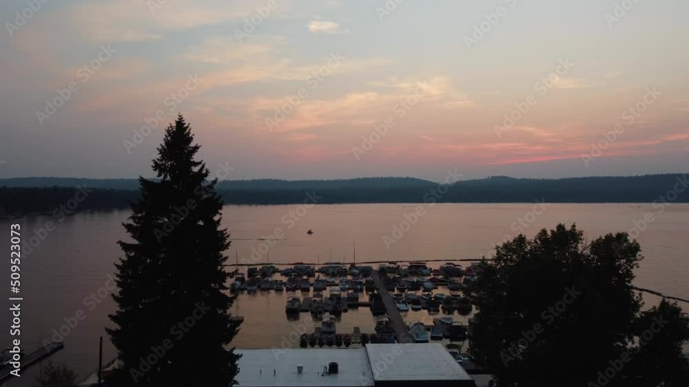 Zoom drone shot through trees on the shore of Payette Lake revealing ...