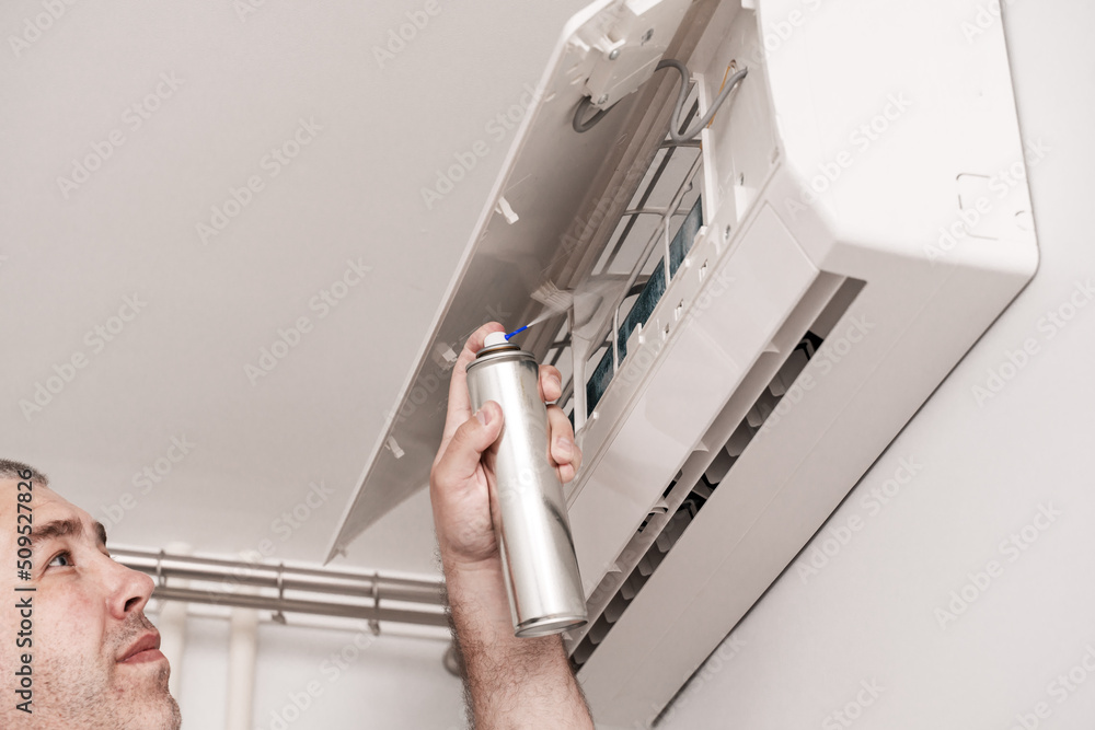 master man washing the indoor unit of a home air conditioner with a ...