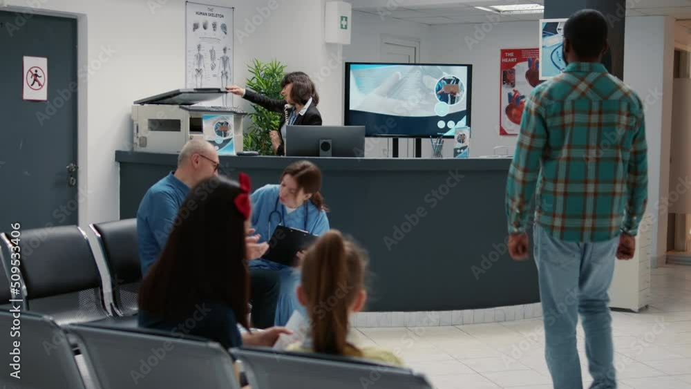 Busy hospital reception waiting area with patients in row to start ...