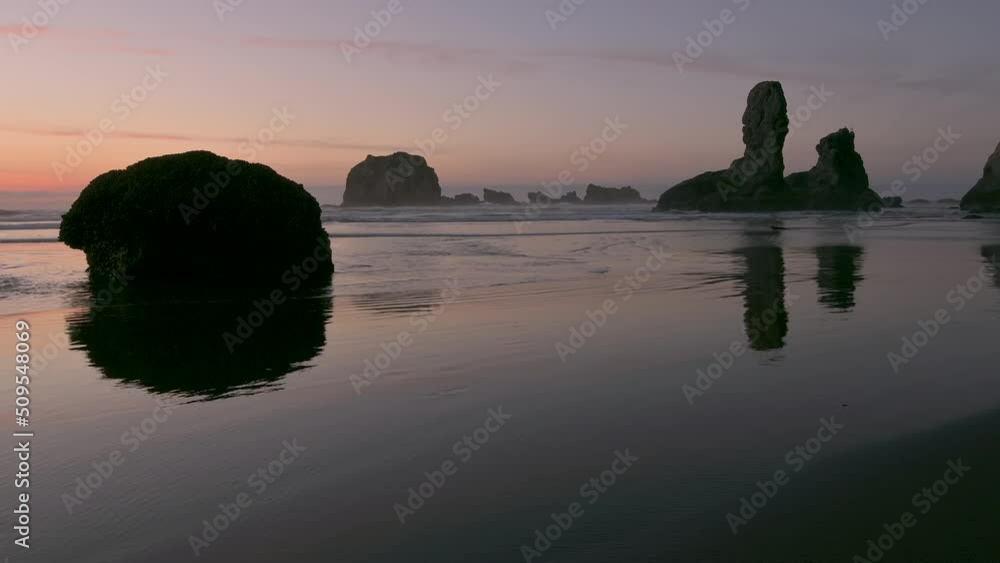 Silhouetted rock formations in Bandon at the Oregon Coast, reflecting ...