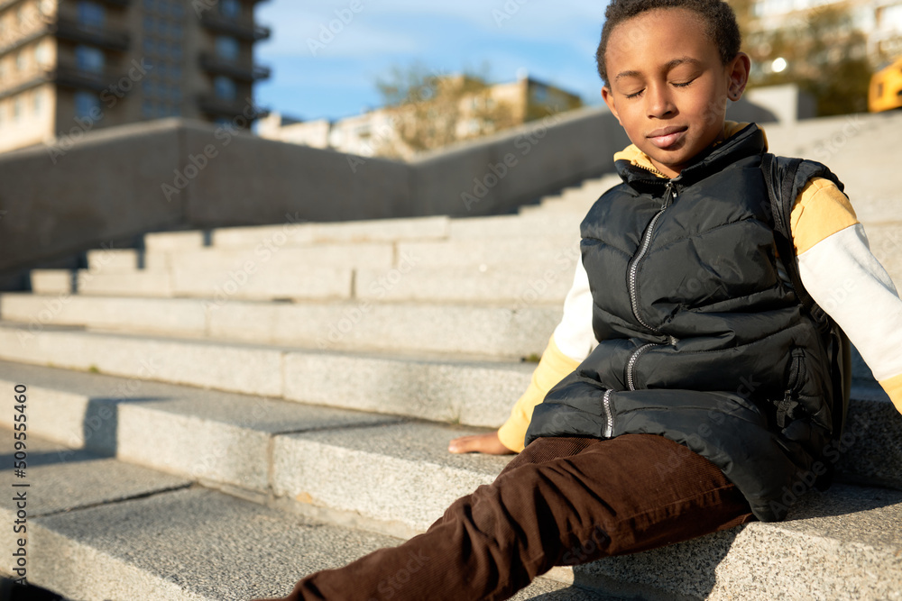 Foto de Handsome boy of african ethnicity in puffer vest and jeans ...