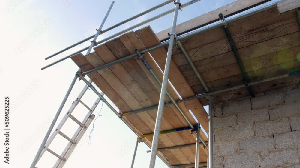 Construction scaffolding and planks on a building for a house extension ...
