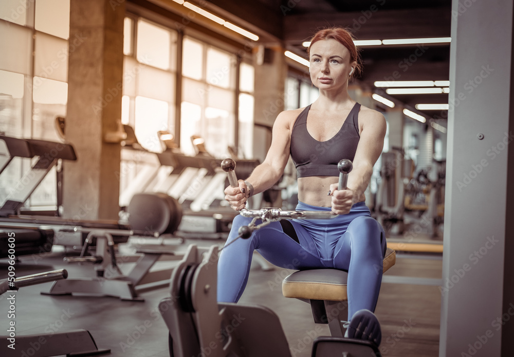 Shot-haired fit woman in sportswear trains back muscles in horizontal ...