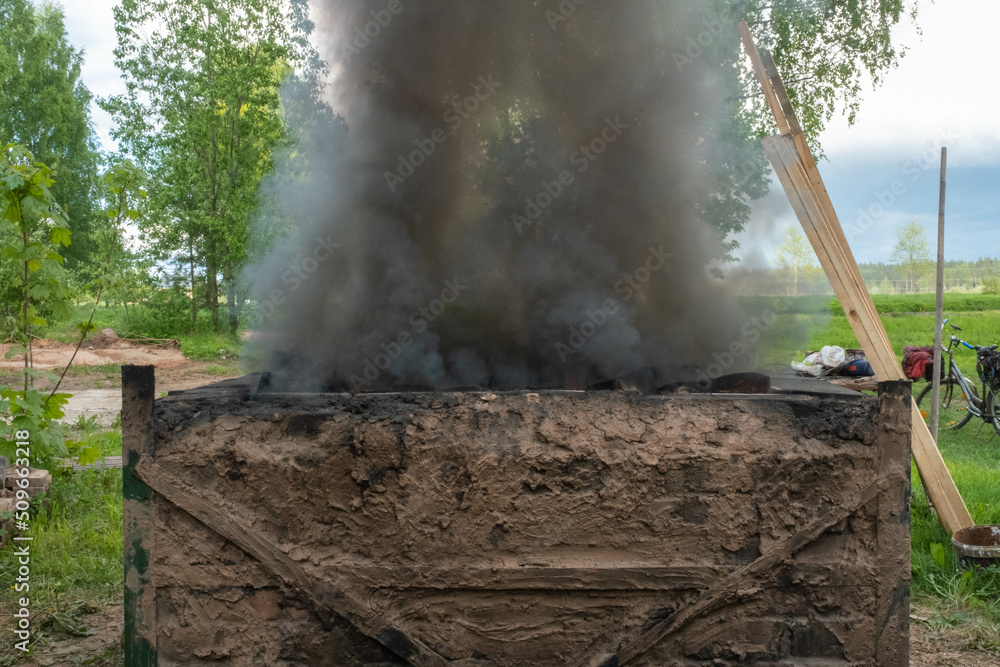 Firing of wood fire kiln is part of process for black pottery. Unique ...