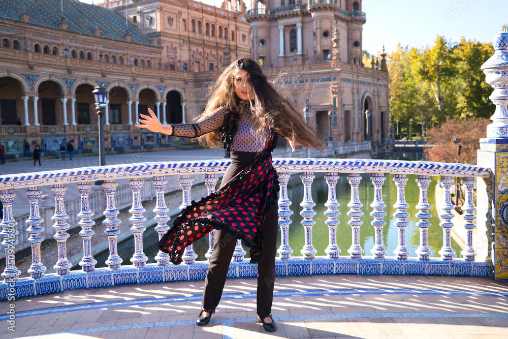 Young and beautiful typical Spanish woman dancing flamenco with urban ...