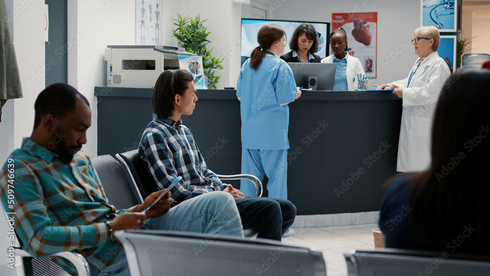 Asian patient in hospital waiting room filling in medical checkup ...