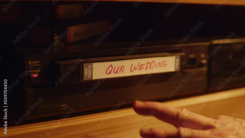 Close Up of a Person Inserting a VHS Cassette in a Player with ...