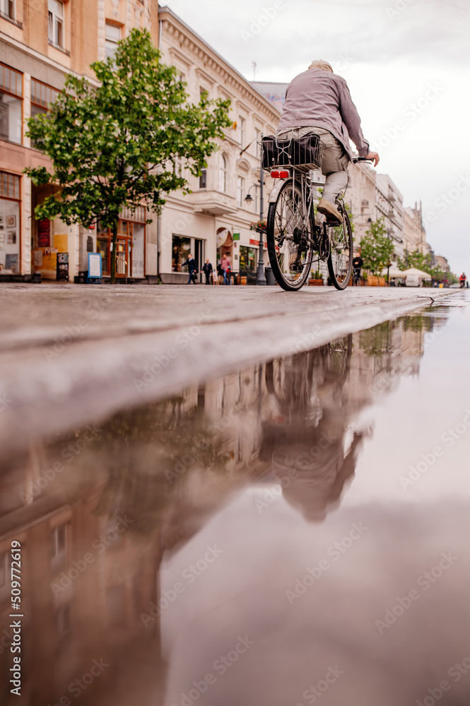 Deszcz i przejeżdżająca na rowerze osoba Stock Photo | Adobe Stock