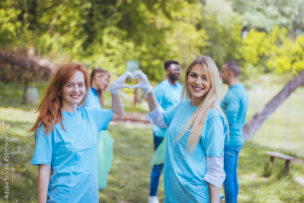 A group of volunteers are cleaning and collecting plastic outside in a ...
