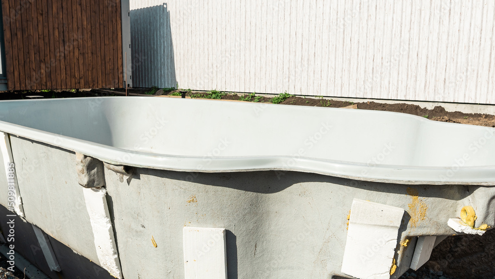 Swimming pool under construction. Installing a fiberglass pool in the ...