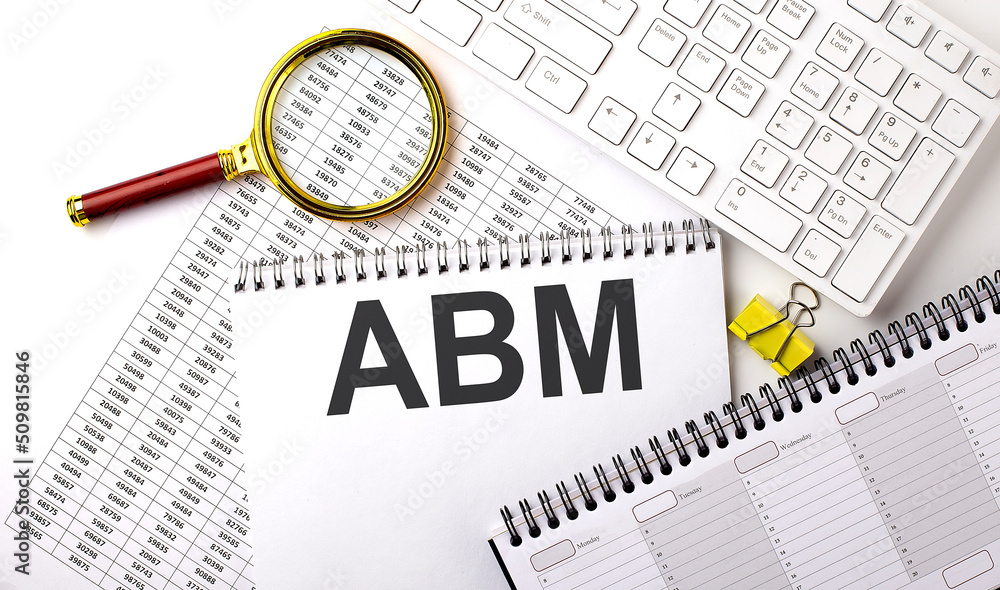 ABM text written on a notebook on chart with keyboard and planning ...