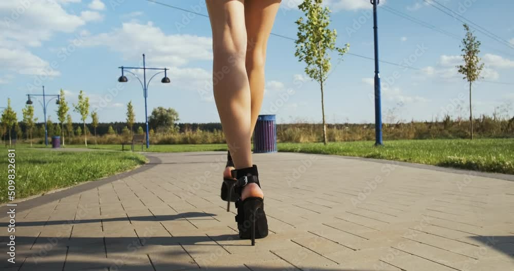 camera follows long female legs in high heels. A woman walks alone ...