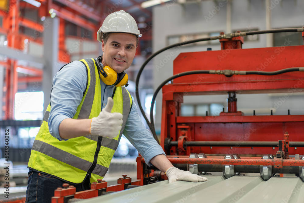 Portrait of male engineer wearing safety vest with white helmet showing ...