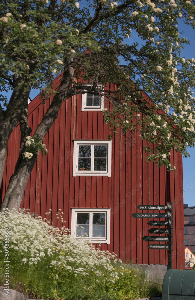 Façade of a red wood building, a pool with directions signs on the ...