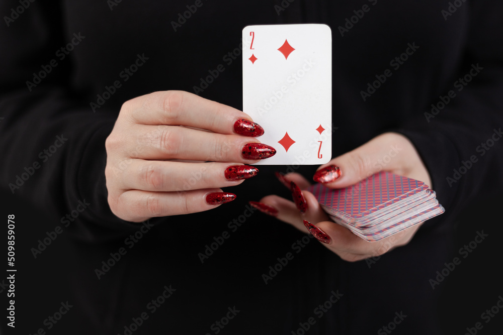 Female hands hold a deck of cards and show tricks. The photographer is ...