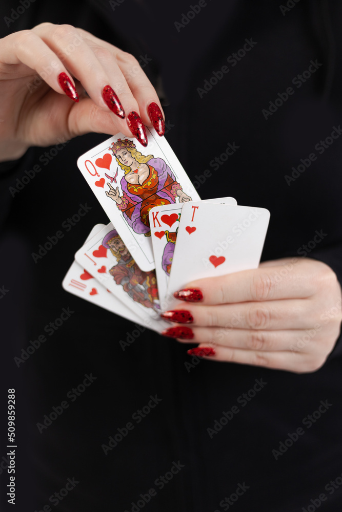 Female hands hold a deck of cards and show tricks. The photographer is ...