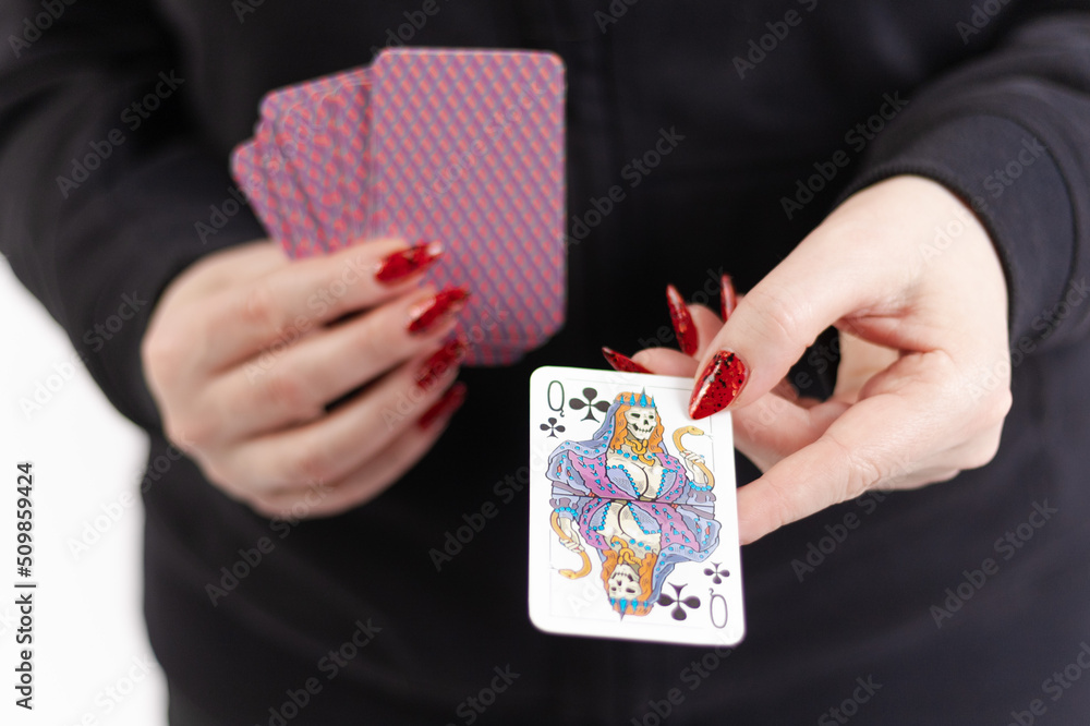 Female hands hold a deck of cards and show tricks. The photographer is ...