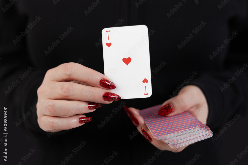 Female hands hold a deck of cards and show tricks. The photographer is ...