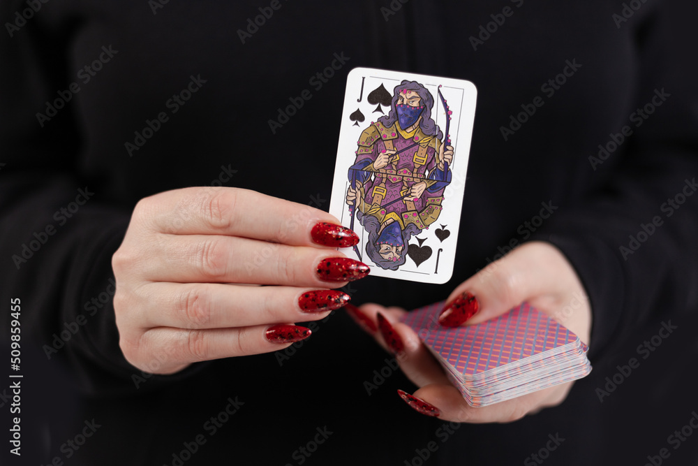 Female hands hold a deck of cards and show tricks. The photographer is ...