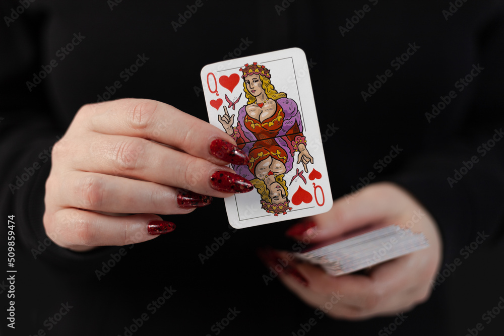 Female hands hold a deck of cards and show tricks. The photographer is ...