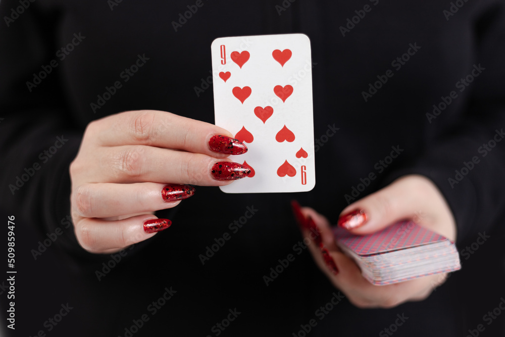 Female hands hold a deck of cards and show tricks. The photographer is ...