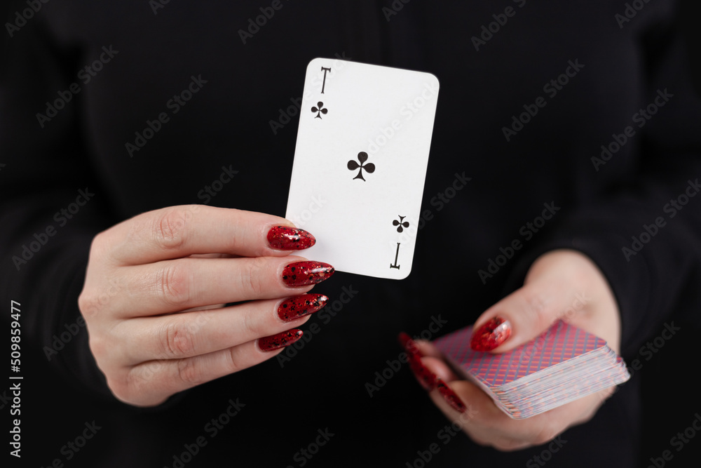 Female hands hold a deck of cards and show tricks. The photographer is ...