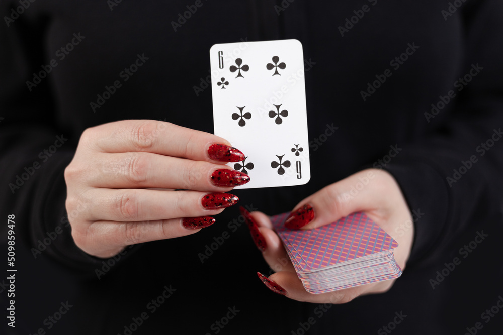 Female hands hold a deck of cards and show tricks. The photographer is ...
