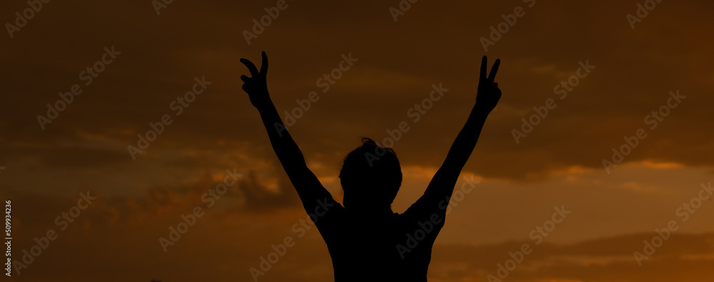 Panoramic Silhouette of a kid raising his arms and doing peace sign ...