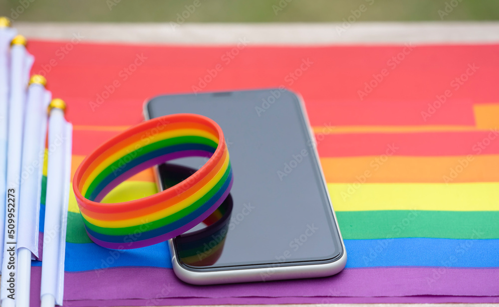 lgbt flags and rainbow wristbands on smartphone with text " Happy pride ...
