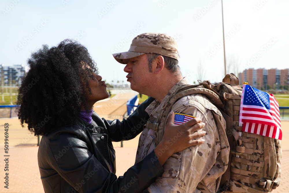 Foto de Beautiful Afro-American woman and American soldier kiss. The ...