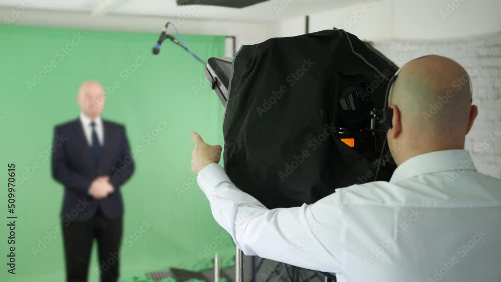 A cameraman counting in for live News TV in green screen video studio ...