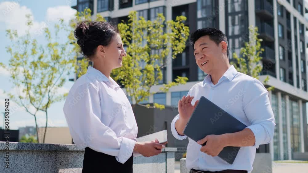 Multinational office workers in formal suit talking outdoors. Asian man ...