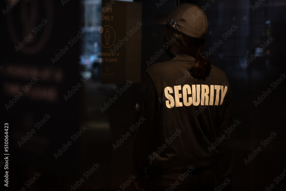 Female security guard walking through an automated revolving curved ...