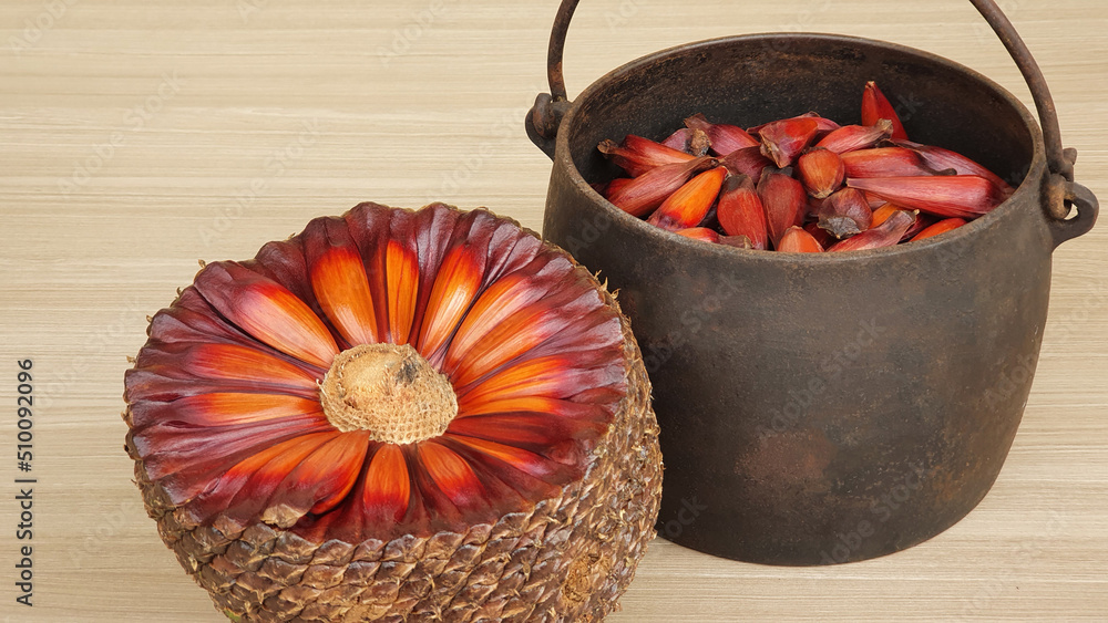 Black iron pot with pine nuts inside and a ball of pine nuts on the ...