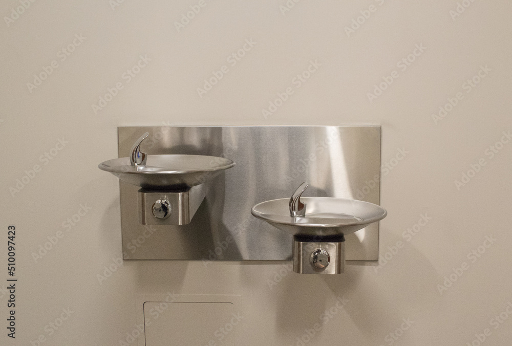 Two drinking water fountains on a wall inside a building. Stock Photo ...