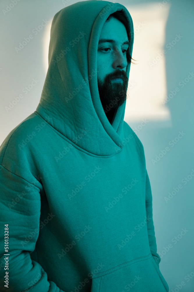 Man in a blue hoodie in blue light Stock Photo | Adobe Stock