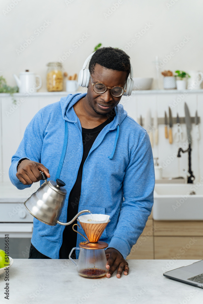 Young black man brewing filter coffee in a kitchen Stock Photo | Adobe ...