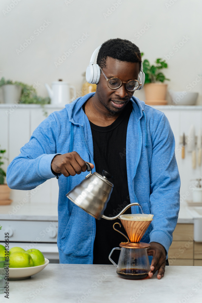 Young black man brewing filter coffee in a kitchen Stock Photo | Adobe ...