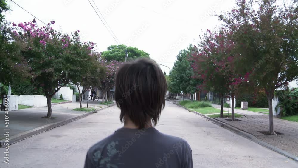 Young Man walking Along an Empty Urban Street. Back View. 4K Resolution ...