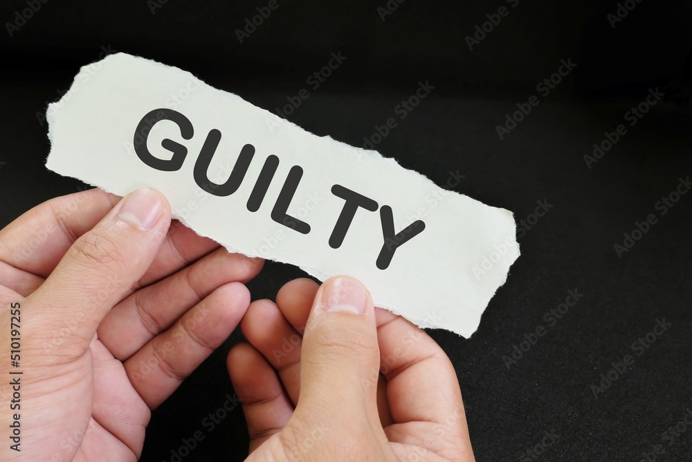 Guilty verdict concept. Hand holding a piece of paper with written word ...