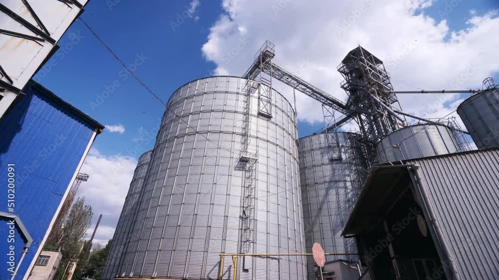 Modern grain elevator terminal in a sea port. Metal tanks and conveyors ...