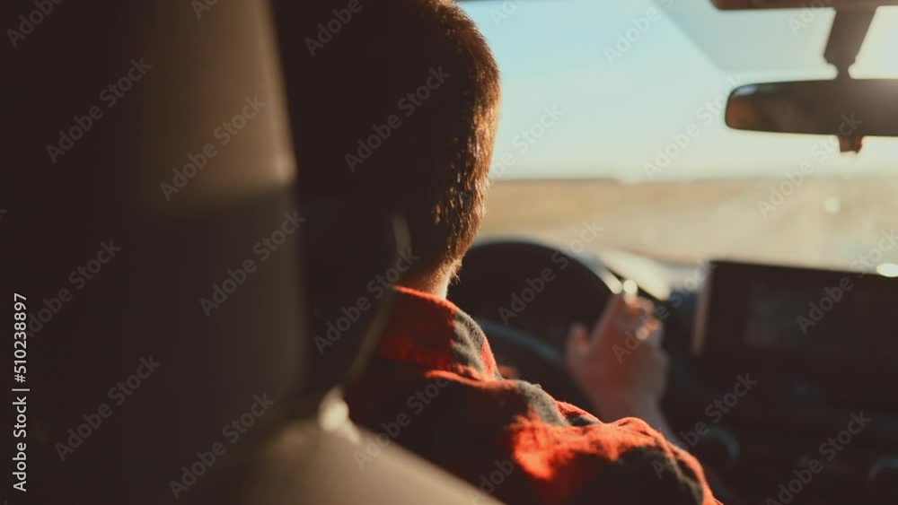 Rear view in saloon auto on male who driving on rural road. Blurred ...