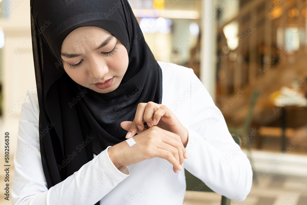Muslim woman having her hand wounded, first aid minor injury treatment ...