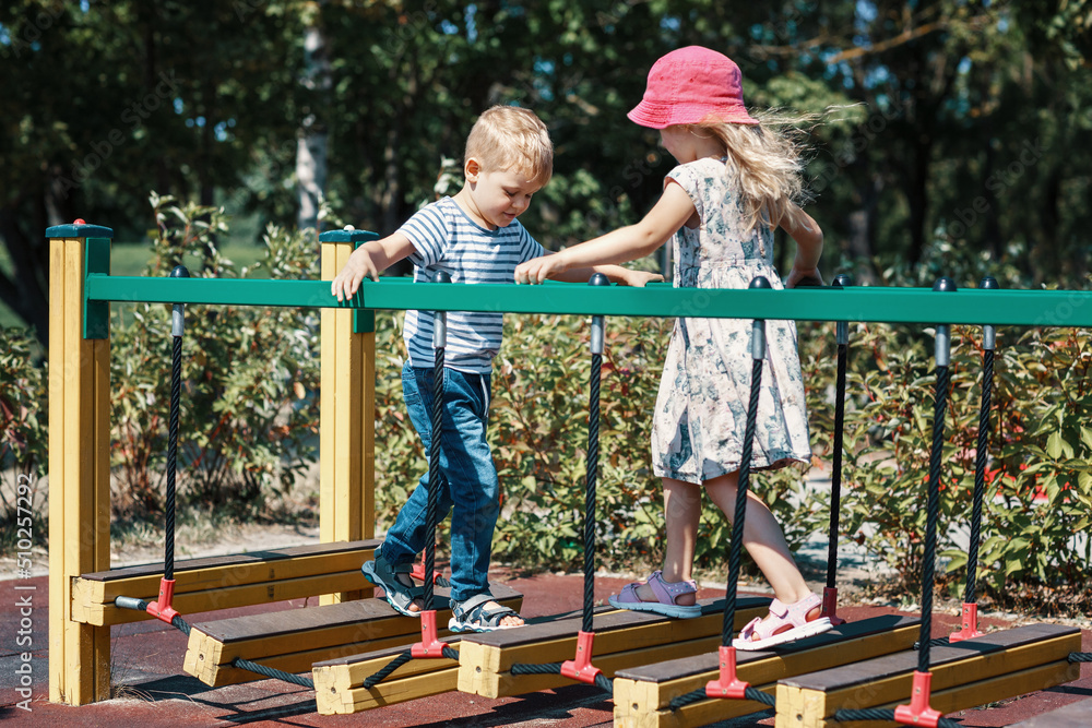 The boy and girl meet each other on a monkey bridge at a city children ...